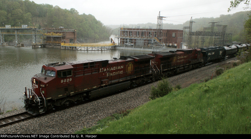 CP 9829 takes oil mtys K08928 west past the dam at Reusens on a gloomy, stormy day